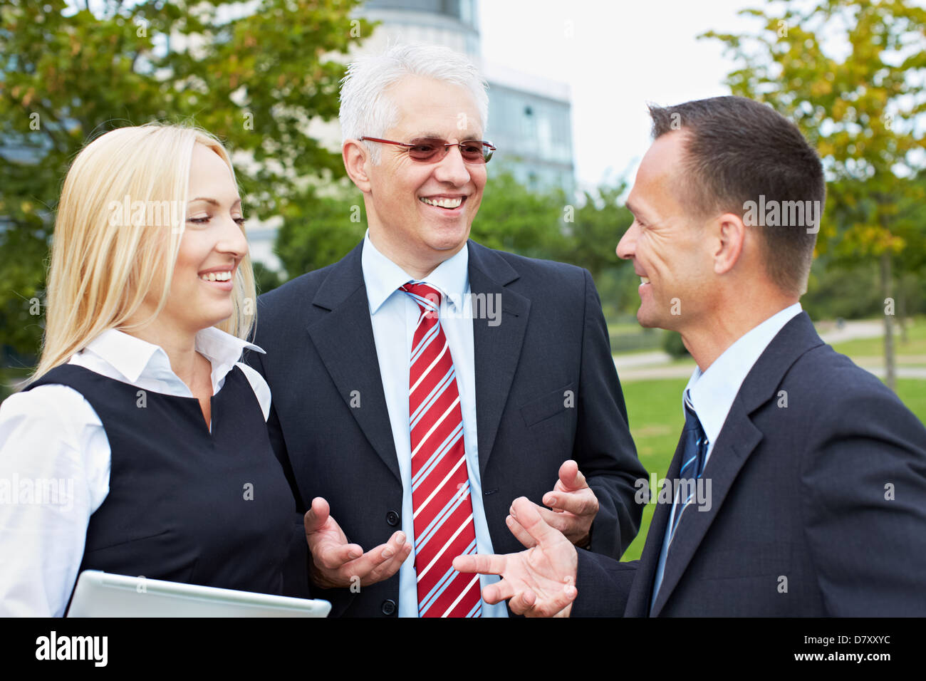 Three business people having a discussion outside in a park Stock Photo ...