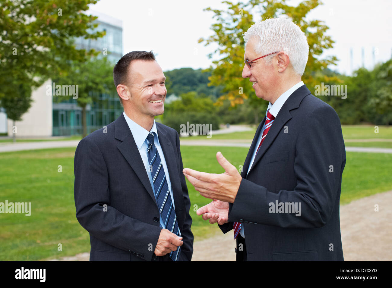 Two happy business people talking with each other in a park Stock Photo ...