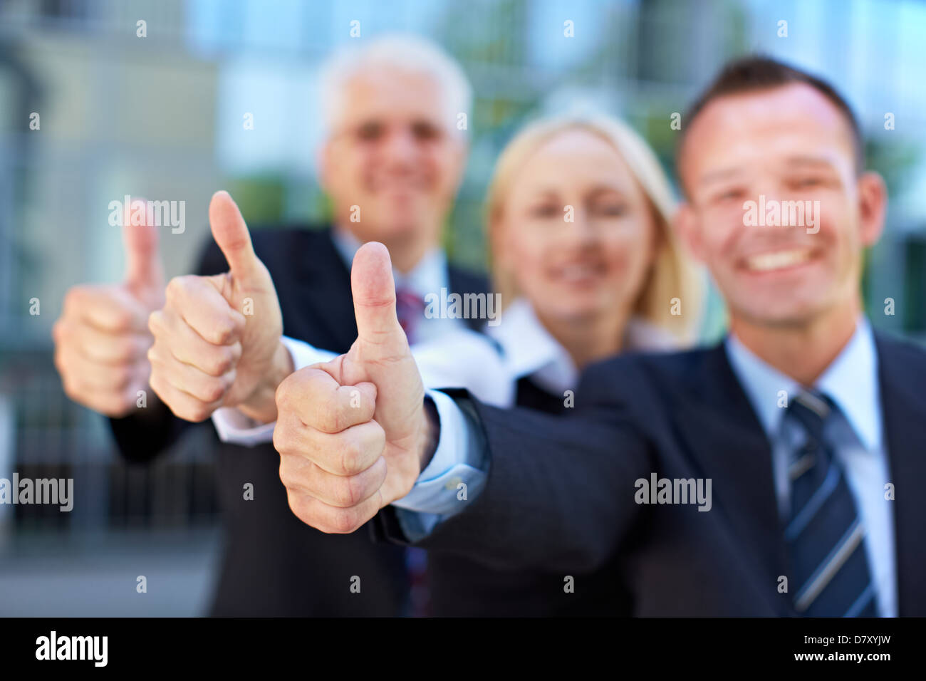 Happy successful business group holding their thumbs up Stock Photo - Alamy