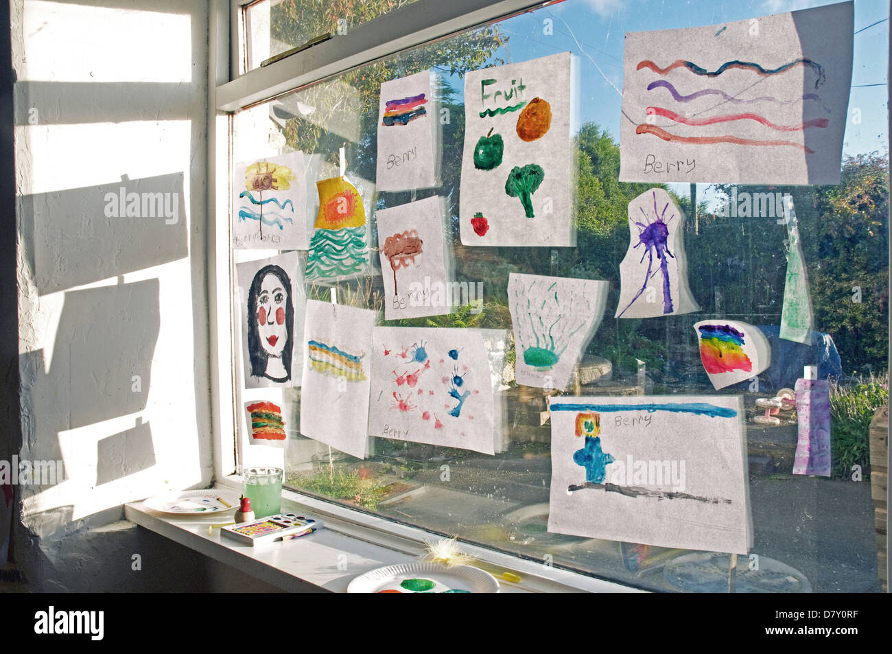 a collection of children's paintings on a window Stock Photo - Alamy