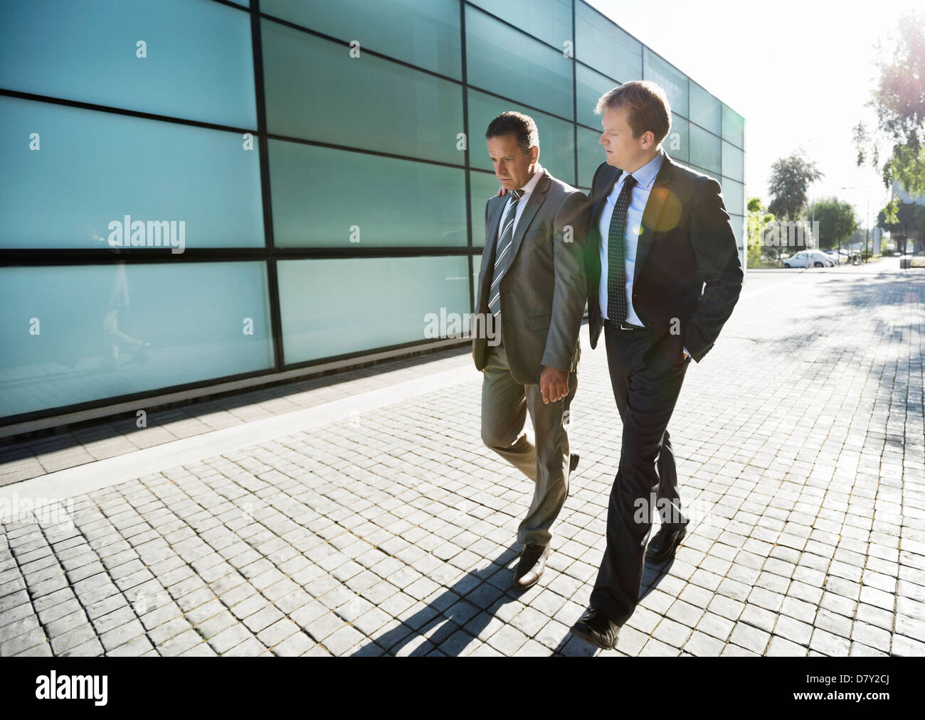 Businessmen walking on city street Stock Photo - Alamy