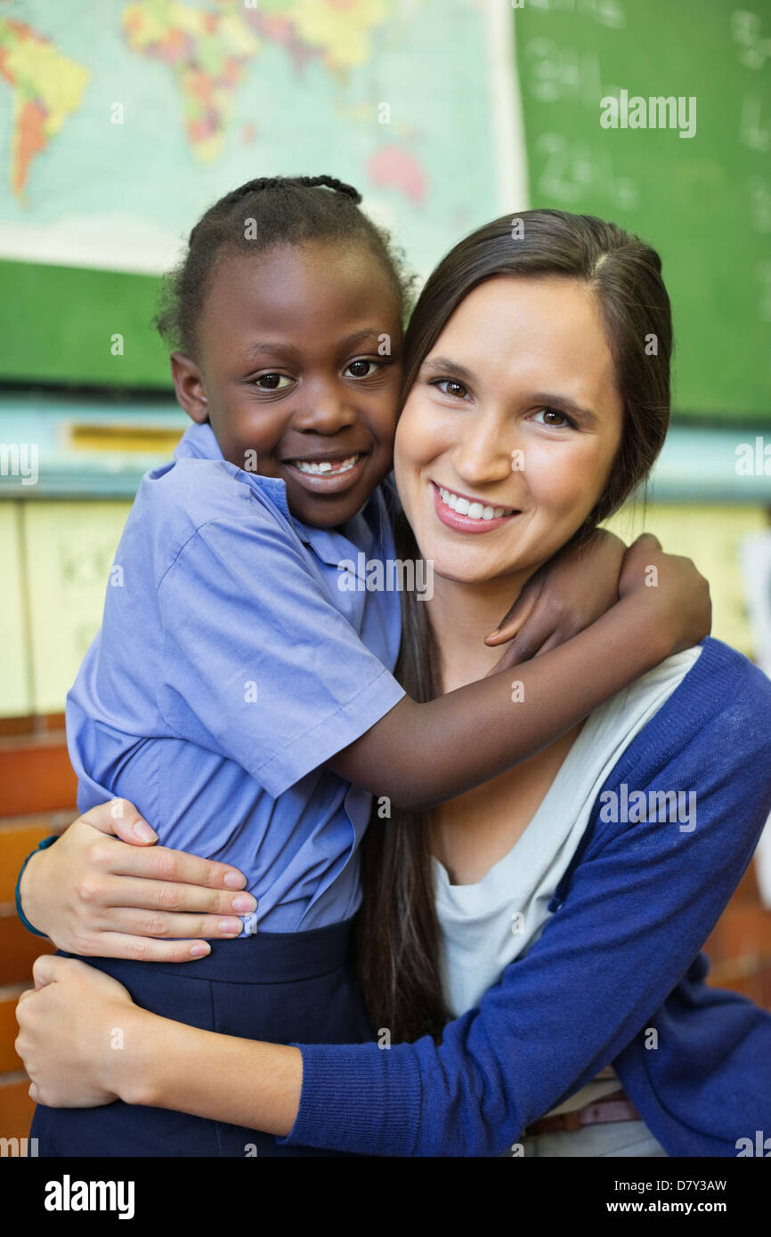 Teacher and student hugging in class Stock Photo - Alamy