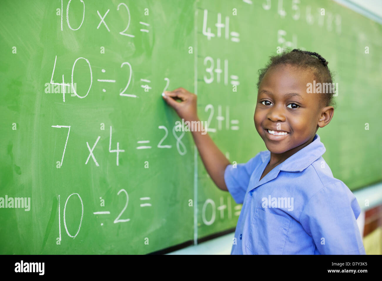 Student writing on blackboard in class Stock Photo - Alamy