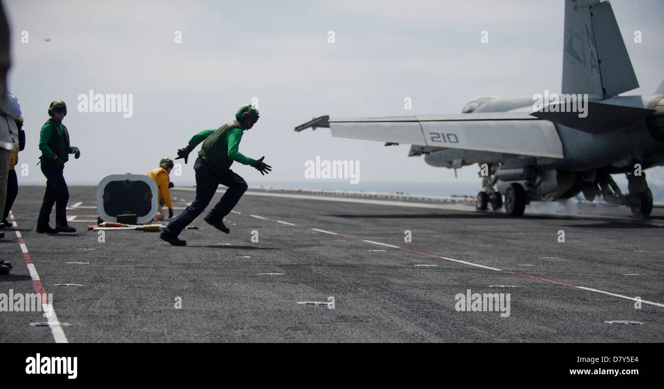 Sailors retrieves hold-back bar during flight operations at sea Stock ...