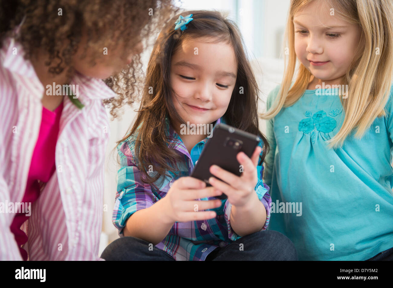 Girls using cell phone together Stock Photo - Alamy