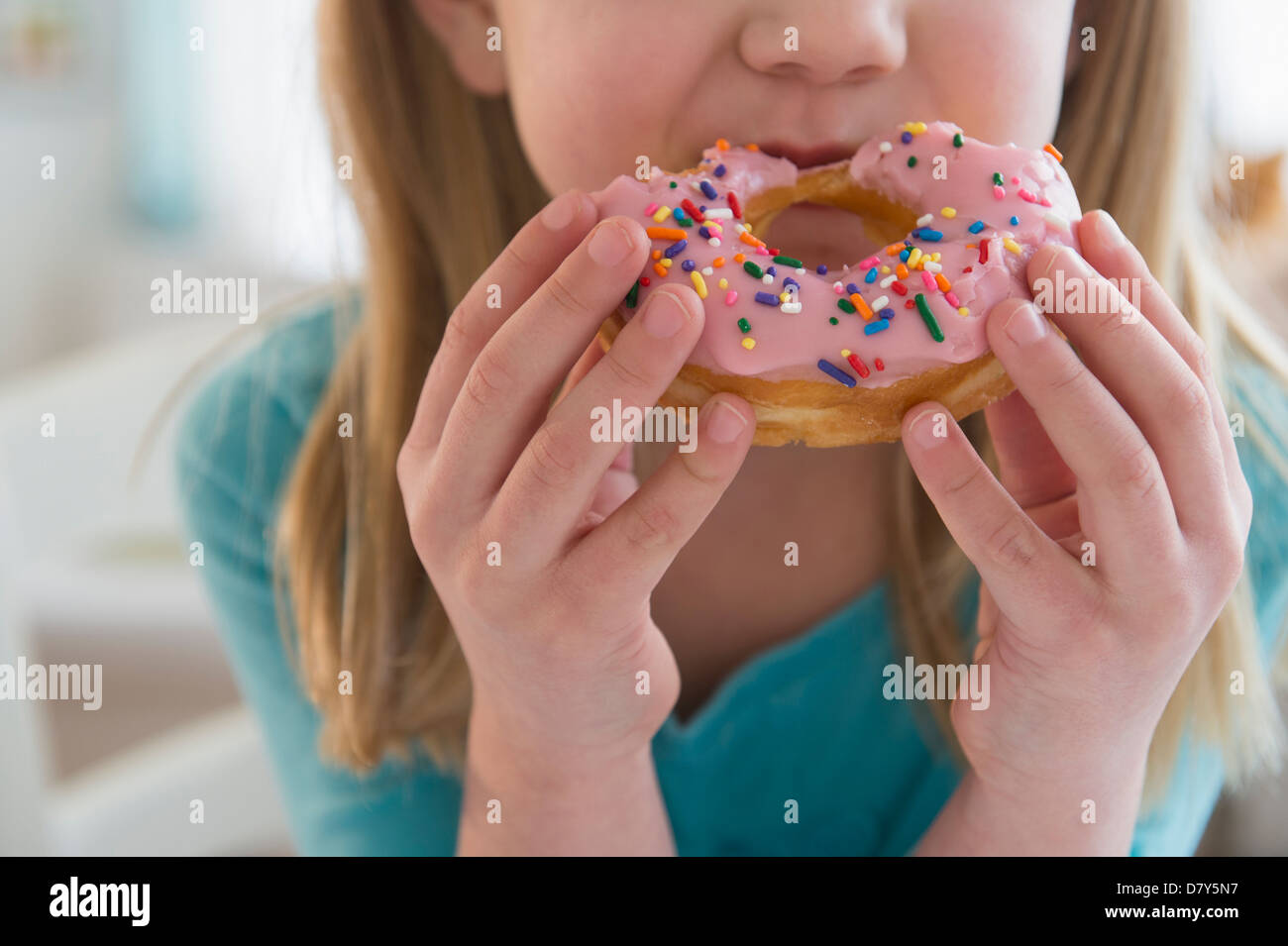 Caucasian girl eating donut Stock Photo - Alamy