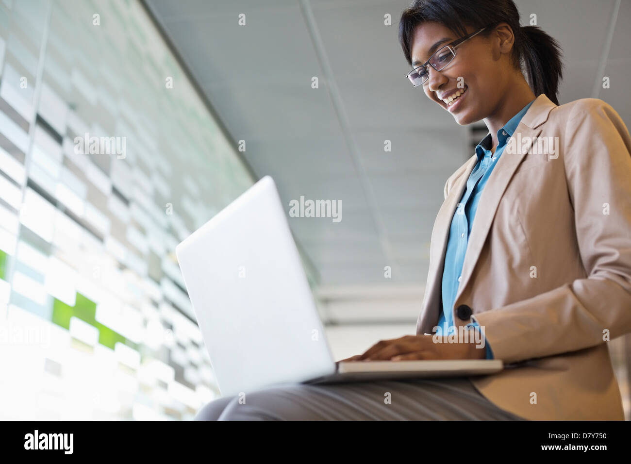 Businesswoman using laptop in office Stock Photo - Alamy