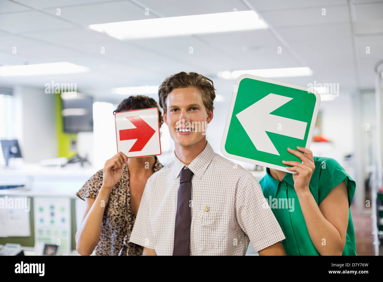 Business people holding arrows in office Stock Photo - Alamy
