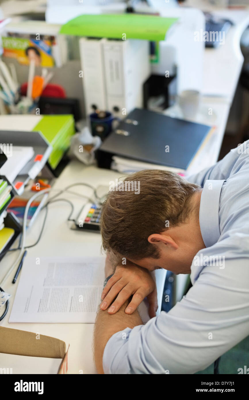 Businessman resting head on desk Stock Photo - Alamy