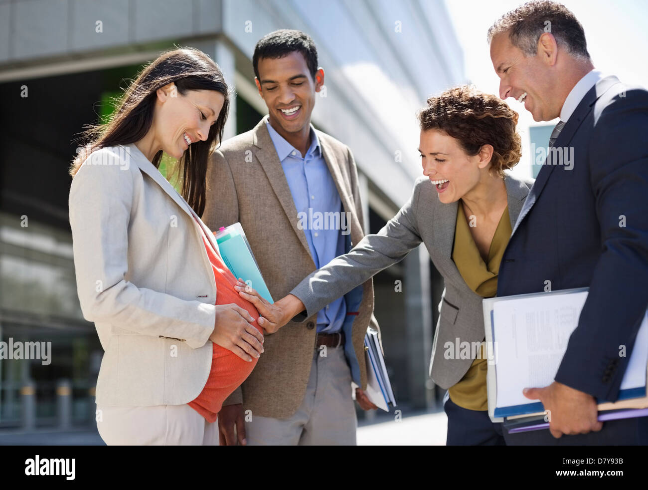 Business people admiring pregnant colleague’s belly Stock Photo - Alamy