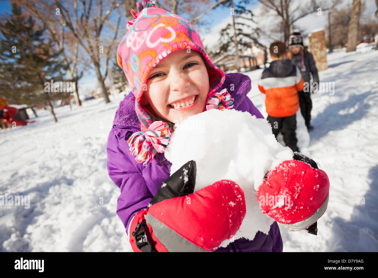 Caucasian girl holding snowball outdoors Stock Photo - Alamy