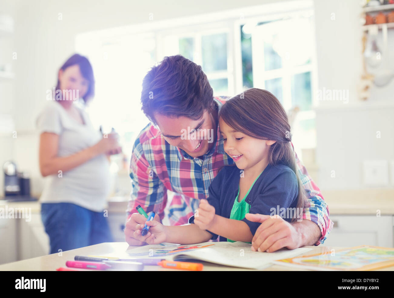 Father helping daughter use coloring book Stock Photo - Alamy