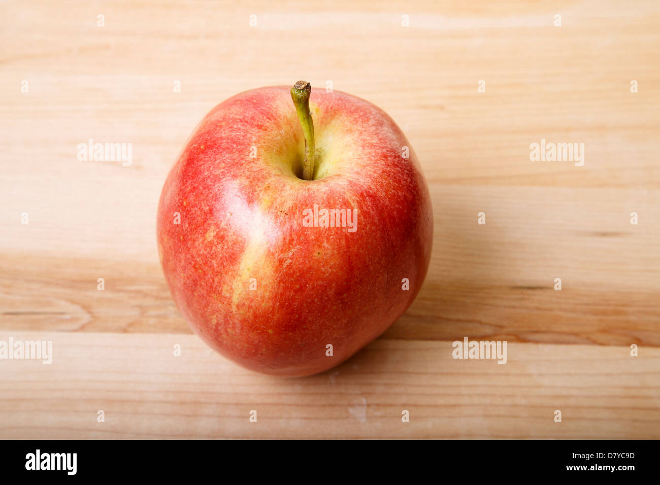 A single red, ripe apple on a wood cutting board Stock Photo - Alamy
