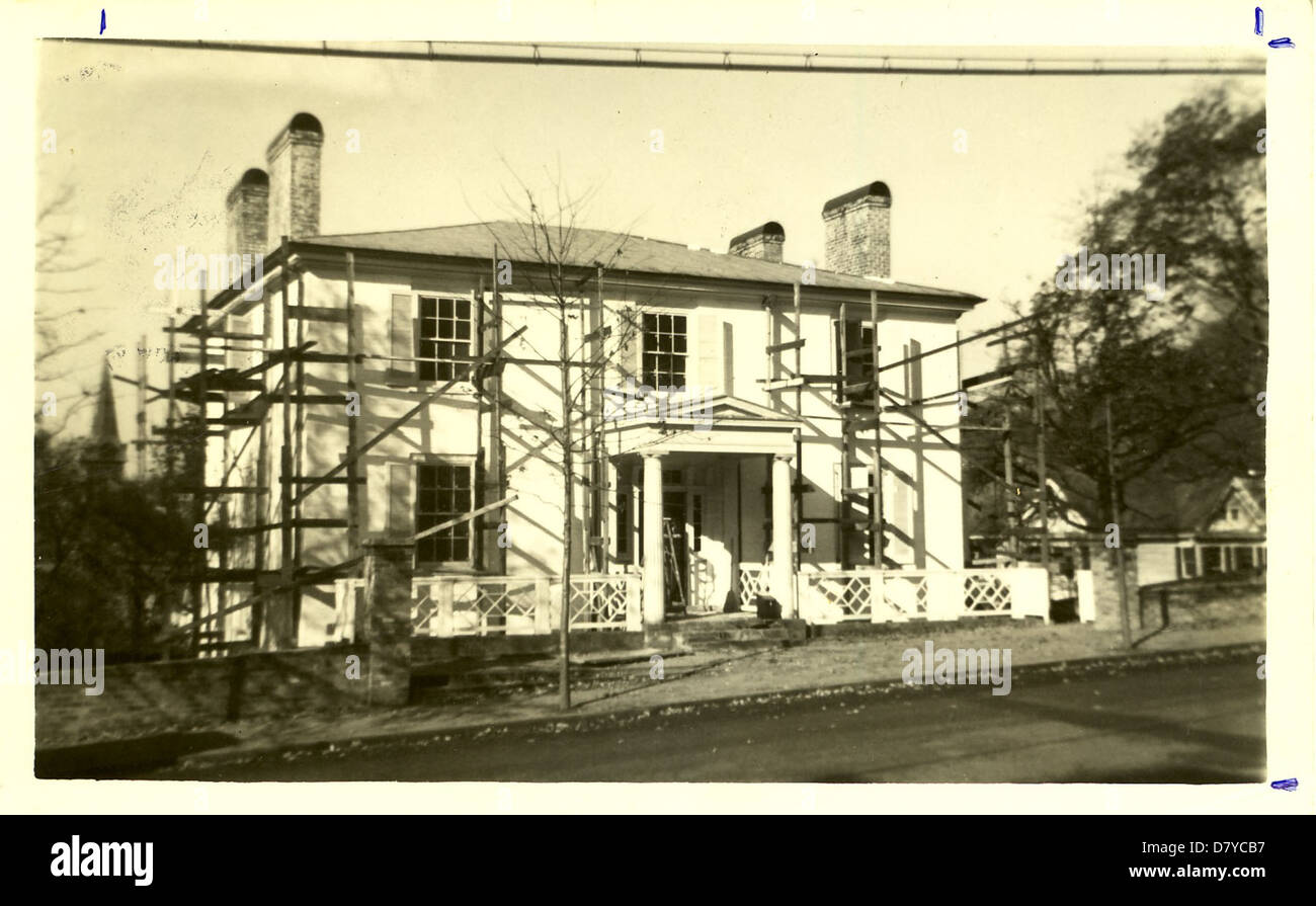 This image captures the restoration of a historic manse, showing ...