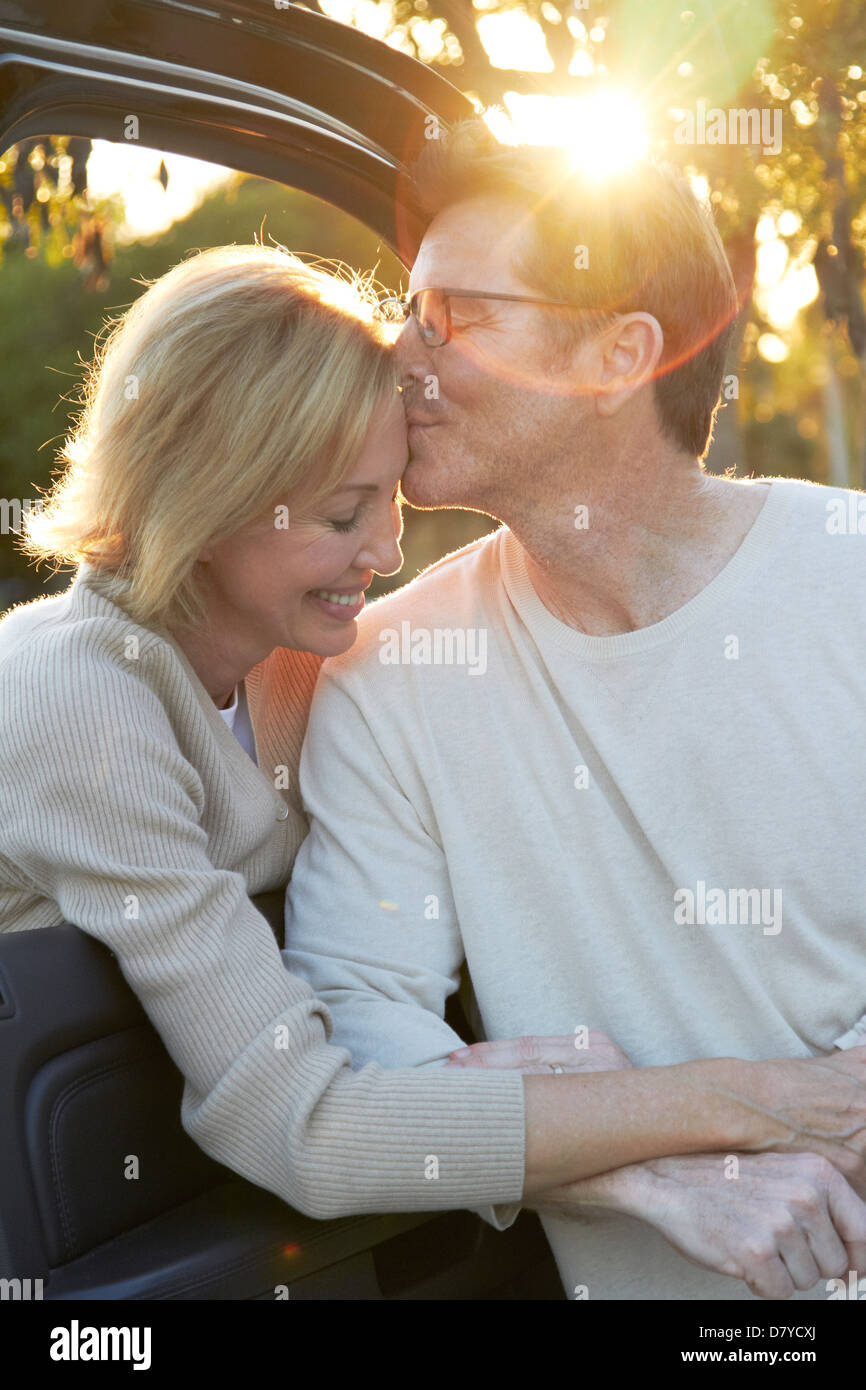 Caucasian couple kissing by car Stock Photo - Alamy