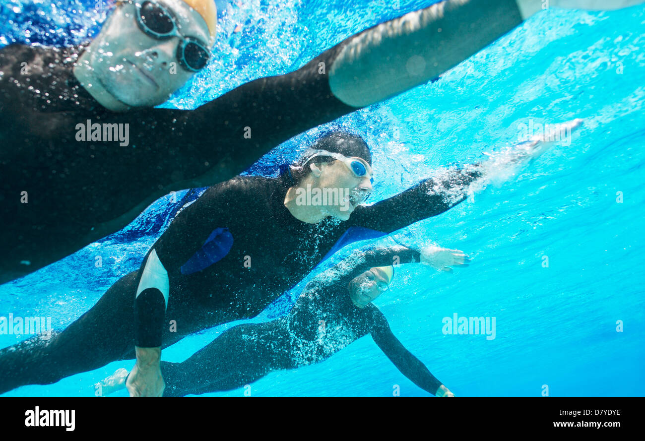 Triathletes in wetsuits underwater Stock Photo - Alamy