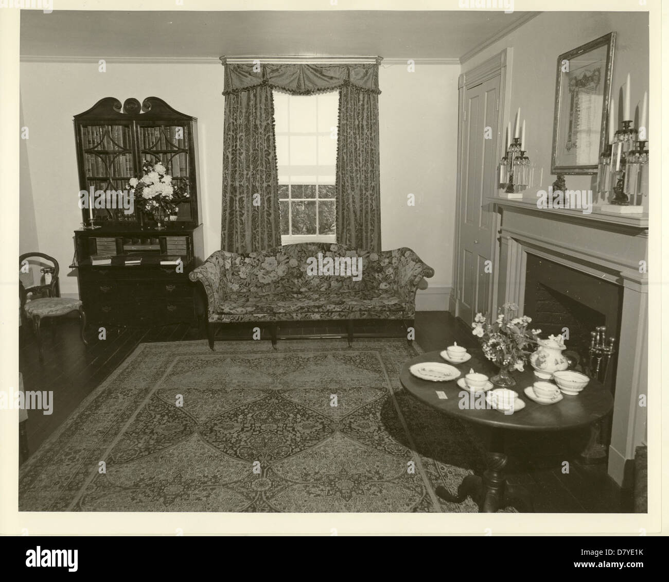 The photograph shows the back parlor of a historical manse, offering a ...