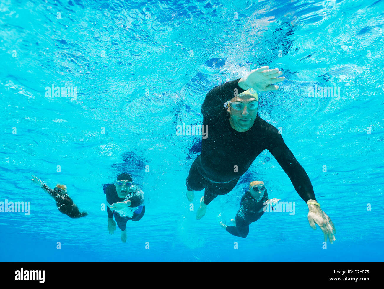 Triathletes in wetsuits underwater Stock Photo - Alamy