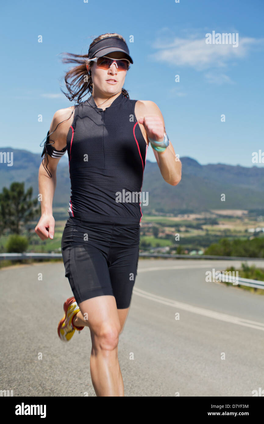 Woman running on rural road Stock Photo - Alamy