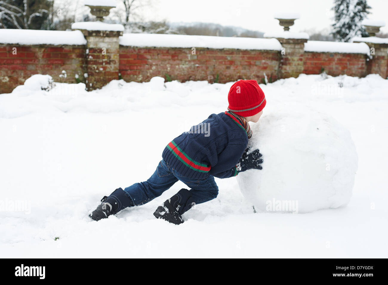 Boy making snowman outdoors Stock Photo - Alamy