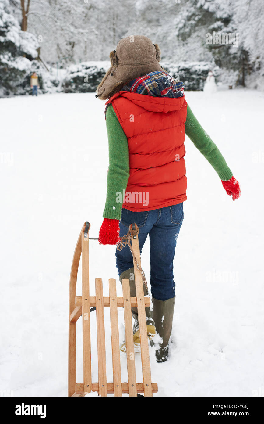 Woman pulling wooden sled in snow Stock Photo - Alamy