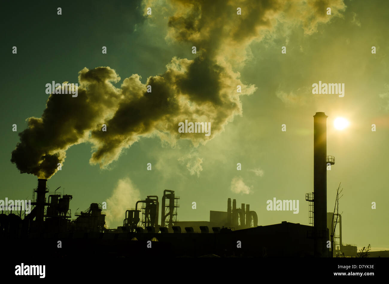 Smoking chimney at sunset on industrial buildings complex Stock Photo ...