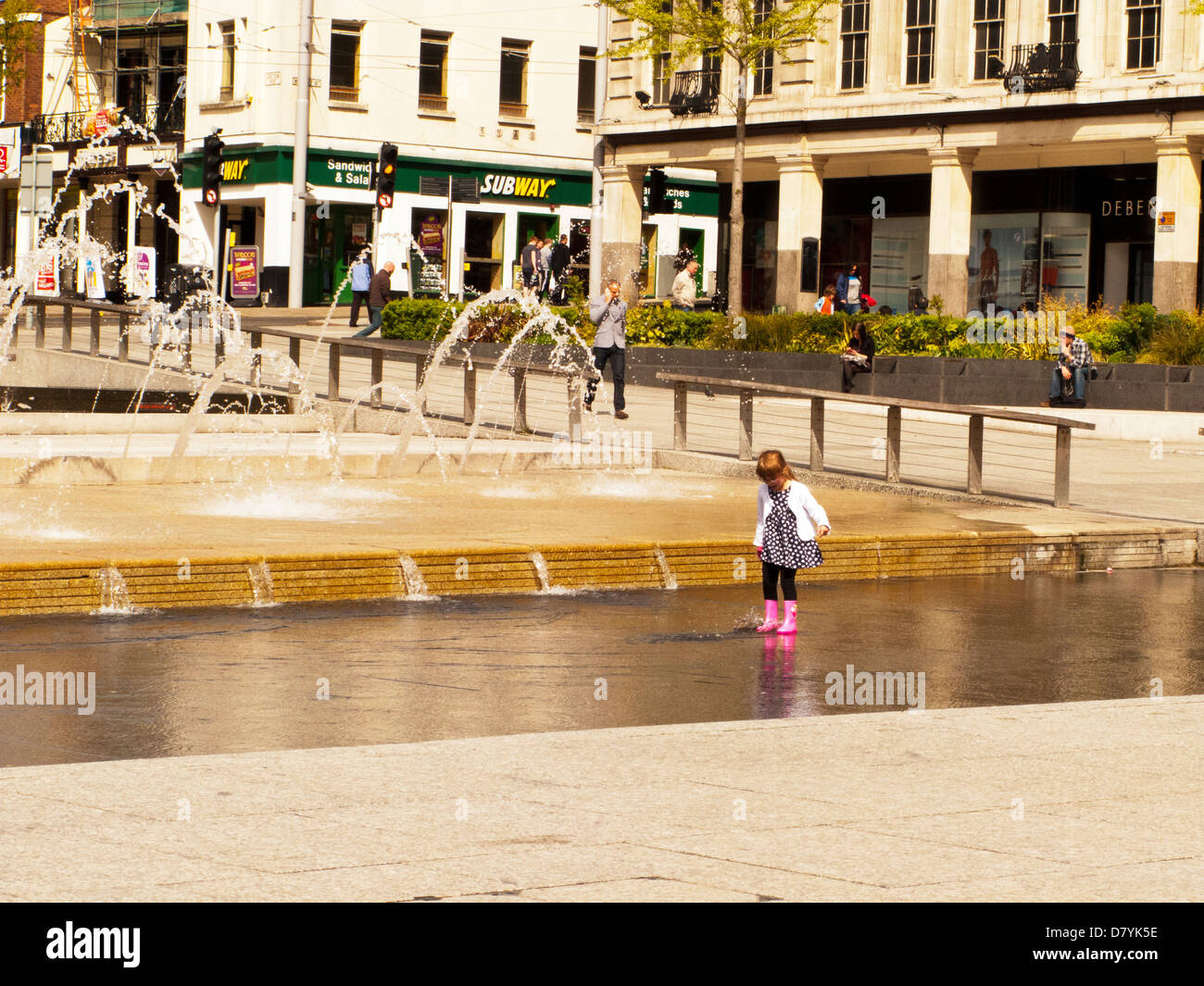 Young girl playing paddling in water at fountain in Nottingham City ...