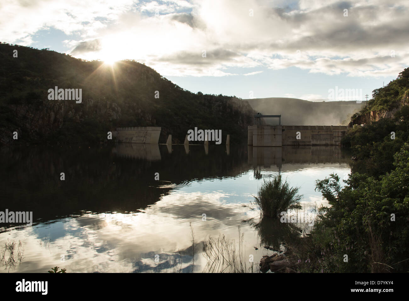 Cloudy day sunrise over a dam wall, creating a starburst and ...