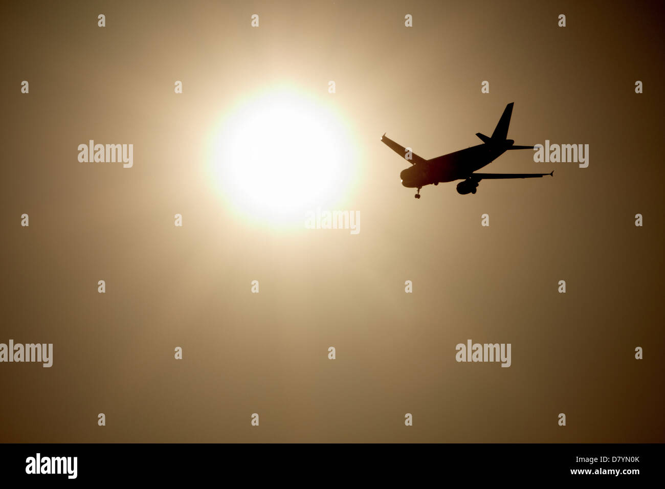 Commercial airplane flying towards the sun Stock Photo - Alamy