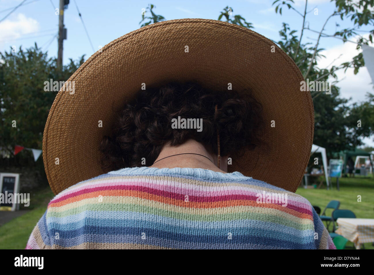 Woman wearing straw hat with head bent forward Stock Photo - Alamy