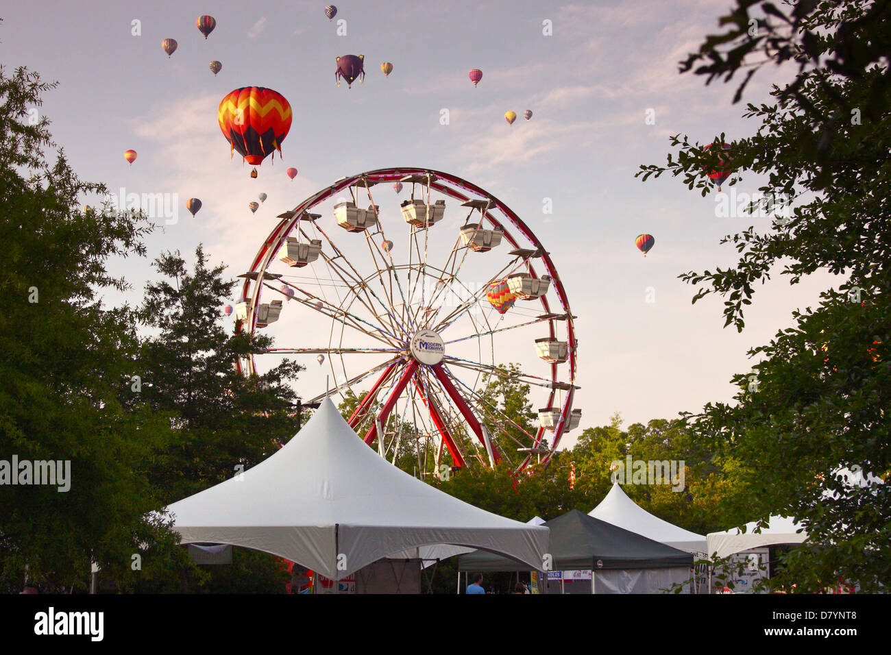 Hot air balloons rise above a ferris wheel and midway at 2011 Freedom ...