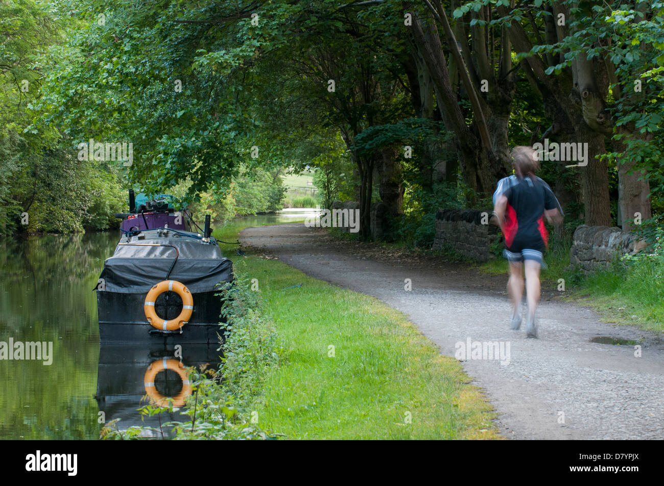 Quiet, scenic, rural, tree-lined stretch of towpath with boats moored ...