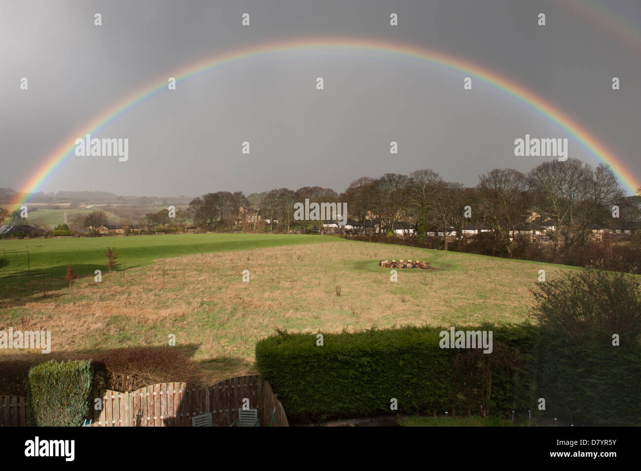 Beautiful rainbow creating a perfect arch across rain clouds in sky ...