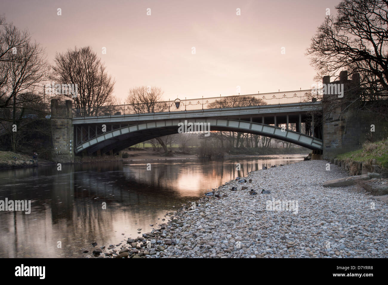 Riverside view of road bridge arching over River Wharfe at Ilkley ...