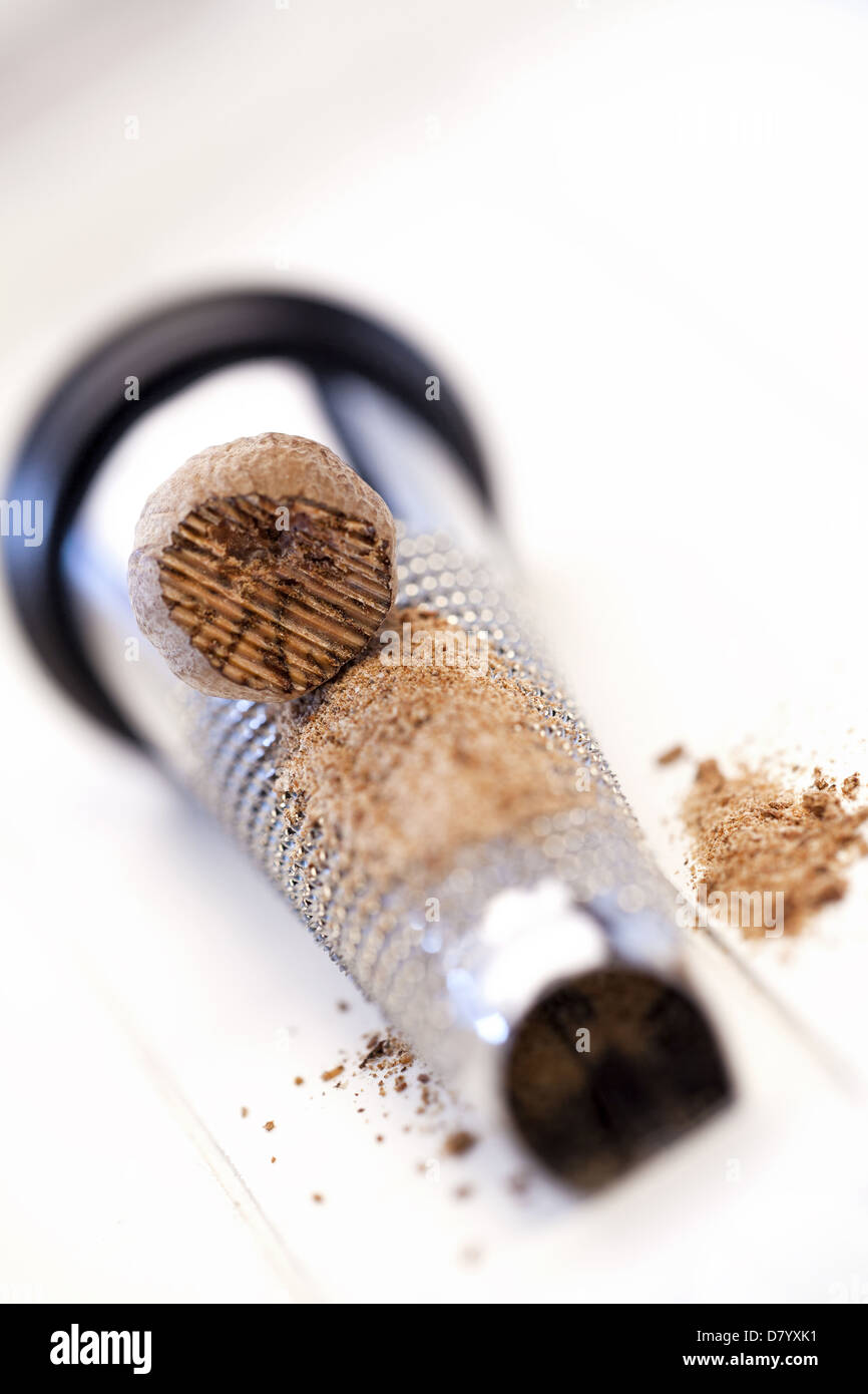 Nutmeg is on a nutmeg grater on a white background Stock Photo - Alamy