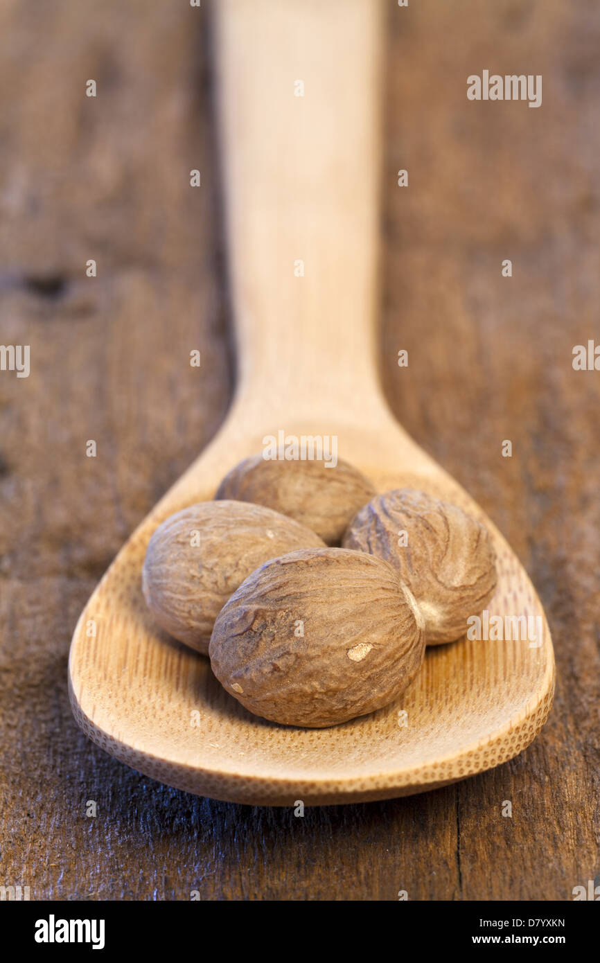 Four Nutmeg on a light wooden spoon Stock Photo - Alamy