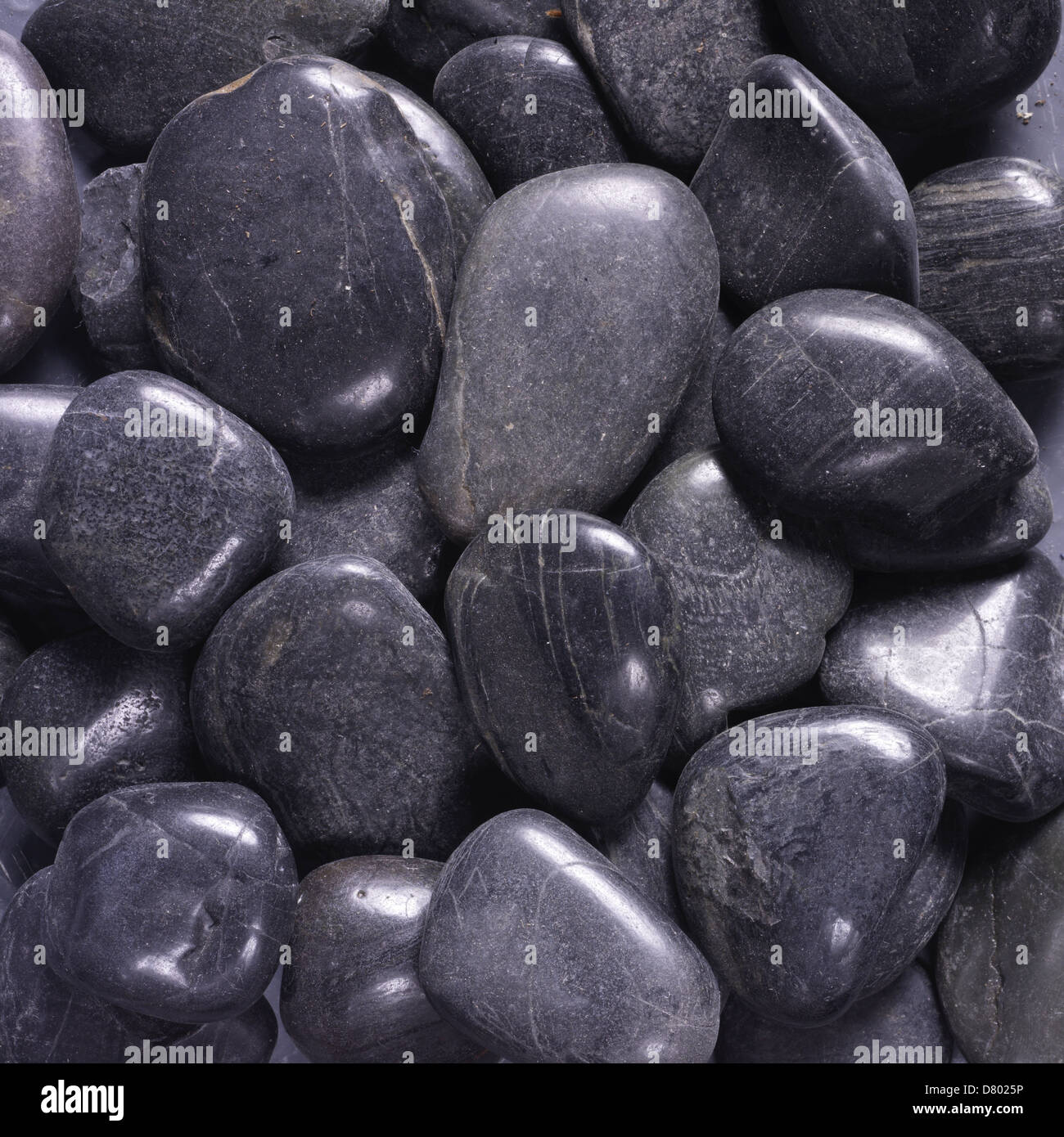 Shiny Black sea side pebbles Stock Photo - Alamy
