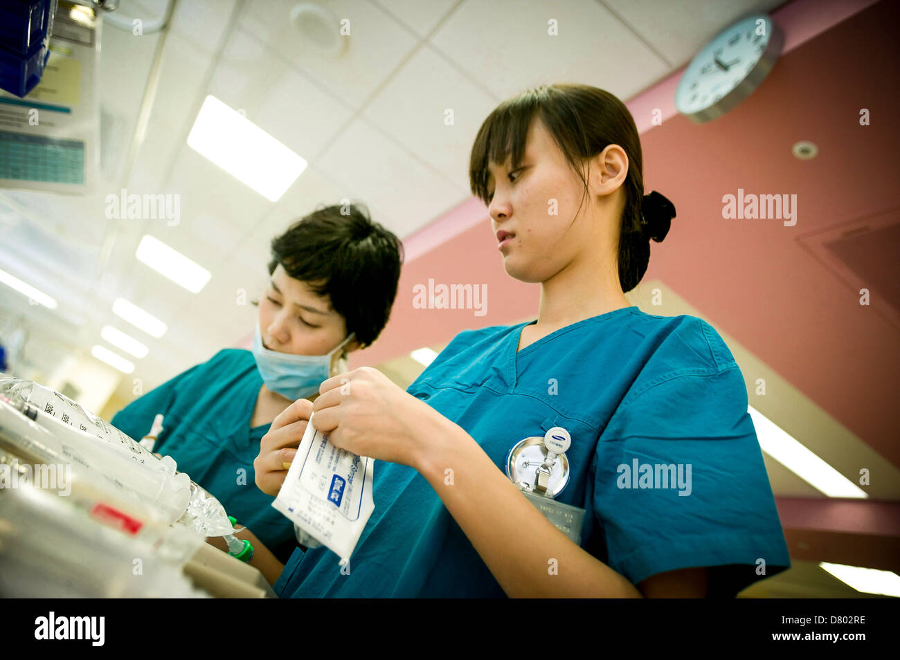 Two nurses prepare equipment and supplies needed on the intensive care ...