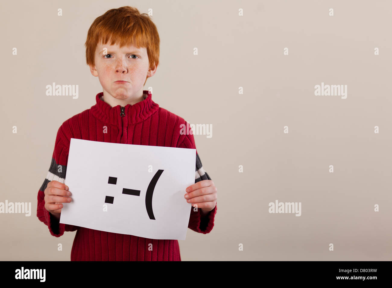 Caucasian boy holding card with sad face Stock Photo - Alamy
