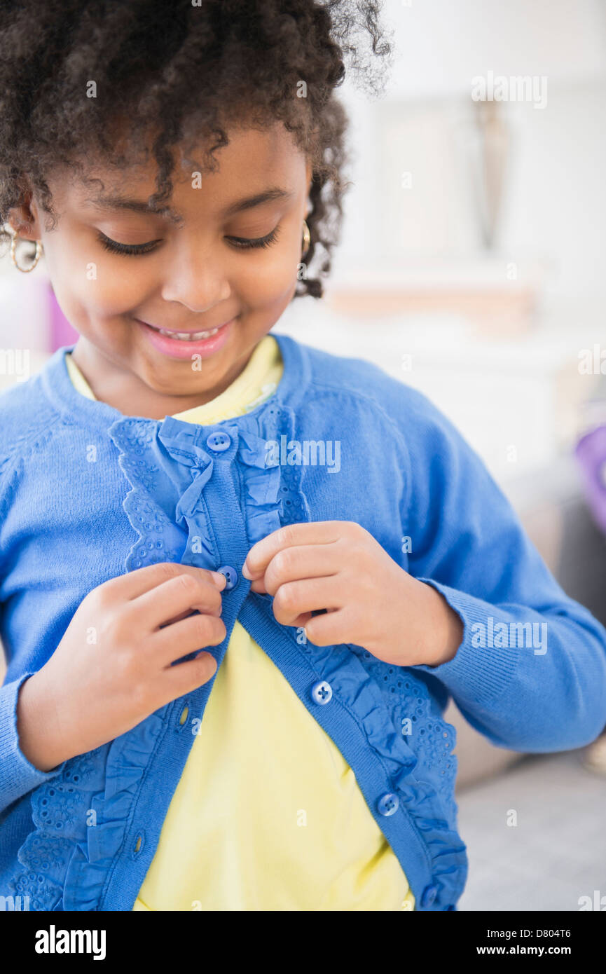 African American girl buttoning her cardigan Stock Photo - Alamy