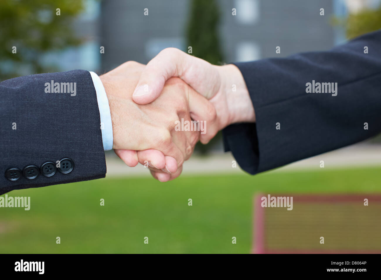 Business people handshake outside in a park Stock Photo - Alamy