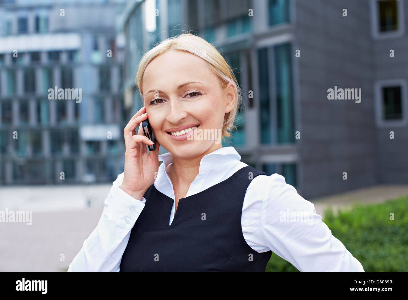 Happy business woman using a smartphone to make a call Stock Photo - Alamy