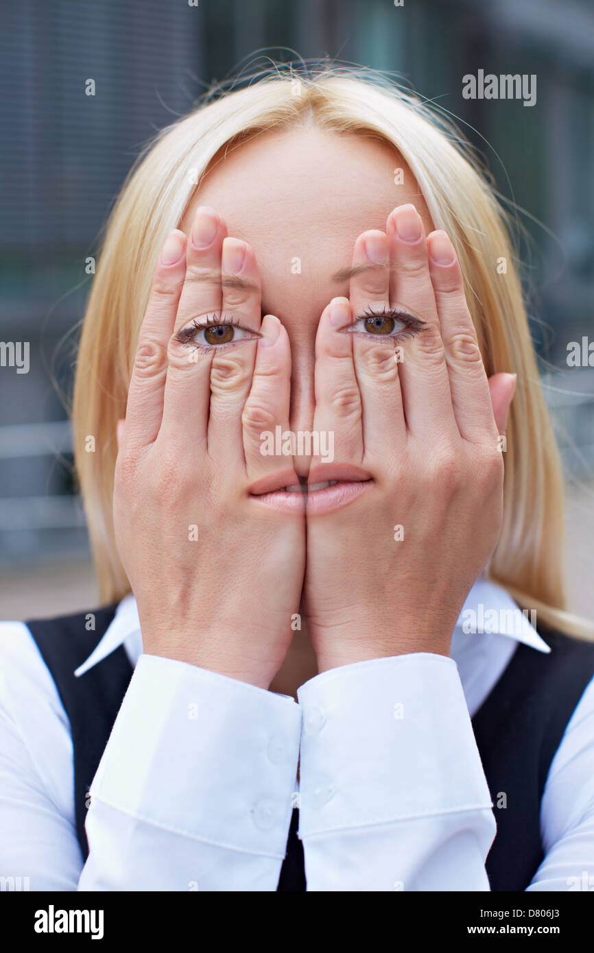 Blonde business woman with face on her hands over her face Stock Photo ...