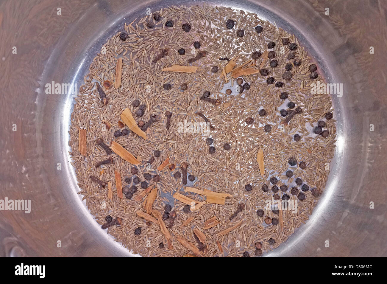 Toasting cumin, cinnamon, cloves and black pepper seeds Stock Photo - Alamy