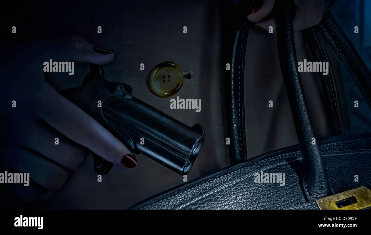 Woman putting pistol in purse Stock Photo - Alamy