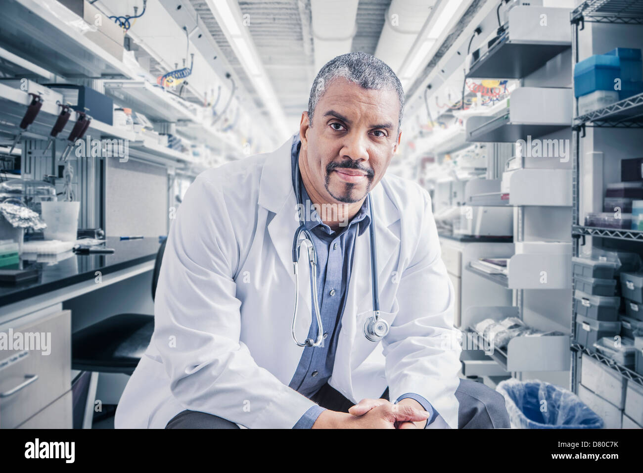 Mixed race doctor sitting at desk in hospital Stock Photo - Alamy