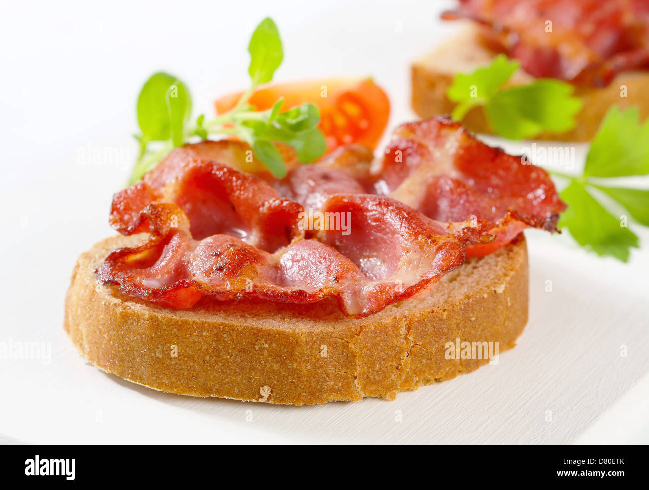 Strips of crispy fried bacon on a slice of bread Stock Photo - Alamy