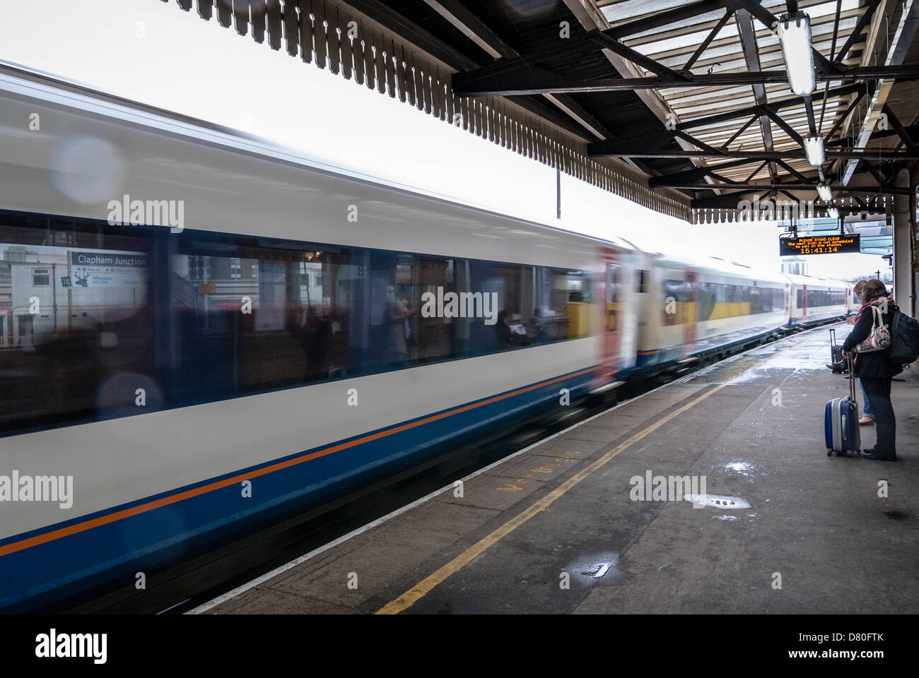 Passengers standing back from non stopping train at Clapham Junction ...