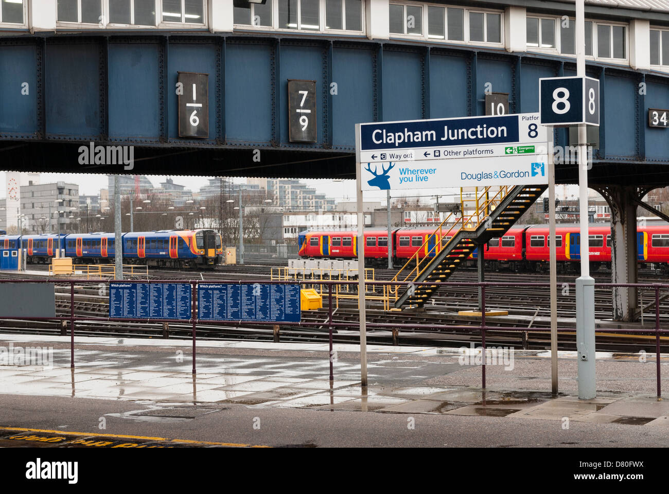 clapham junction platforms and railway tracks and sign in the rain ...