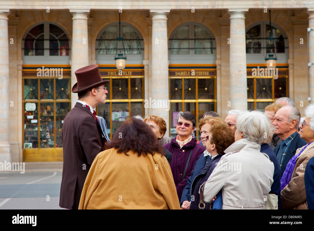 Costumed tour guide with his tour group at Palais Royal, Paris France ...